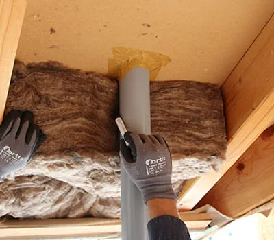 Cutting insulation between rafters for pipe openings